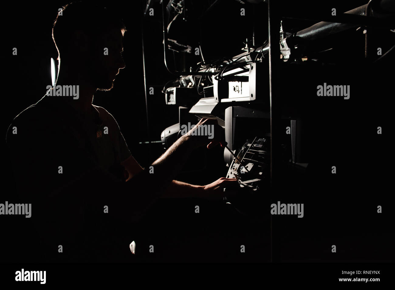 The lighting engineer repairs the light device on stage Stock Photo - Alamy