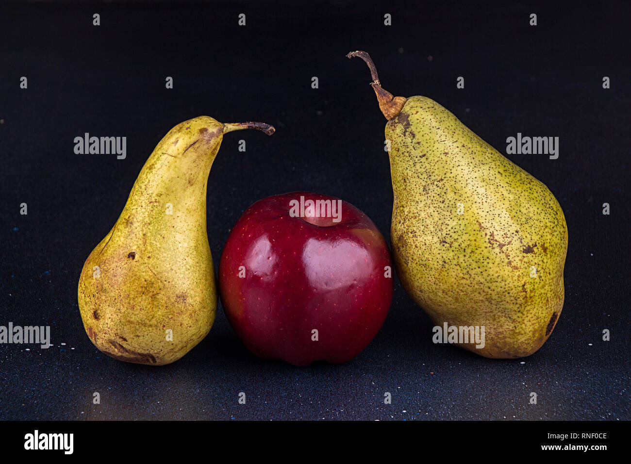 One apple and two pears on darc background. Homegrown organic fruits ...