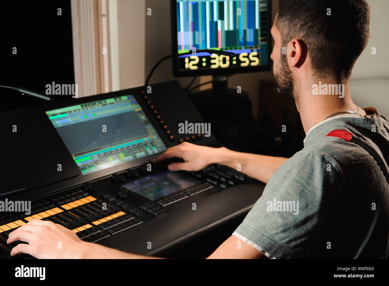 A lighting engineer works with lights technicians control Stock Photo ...