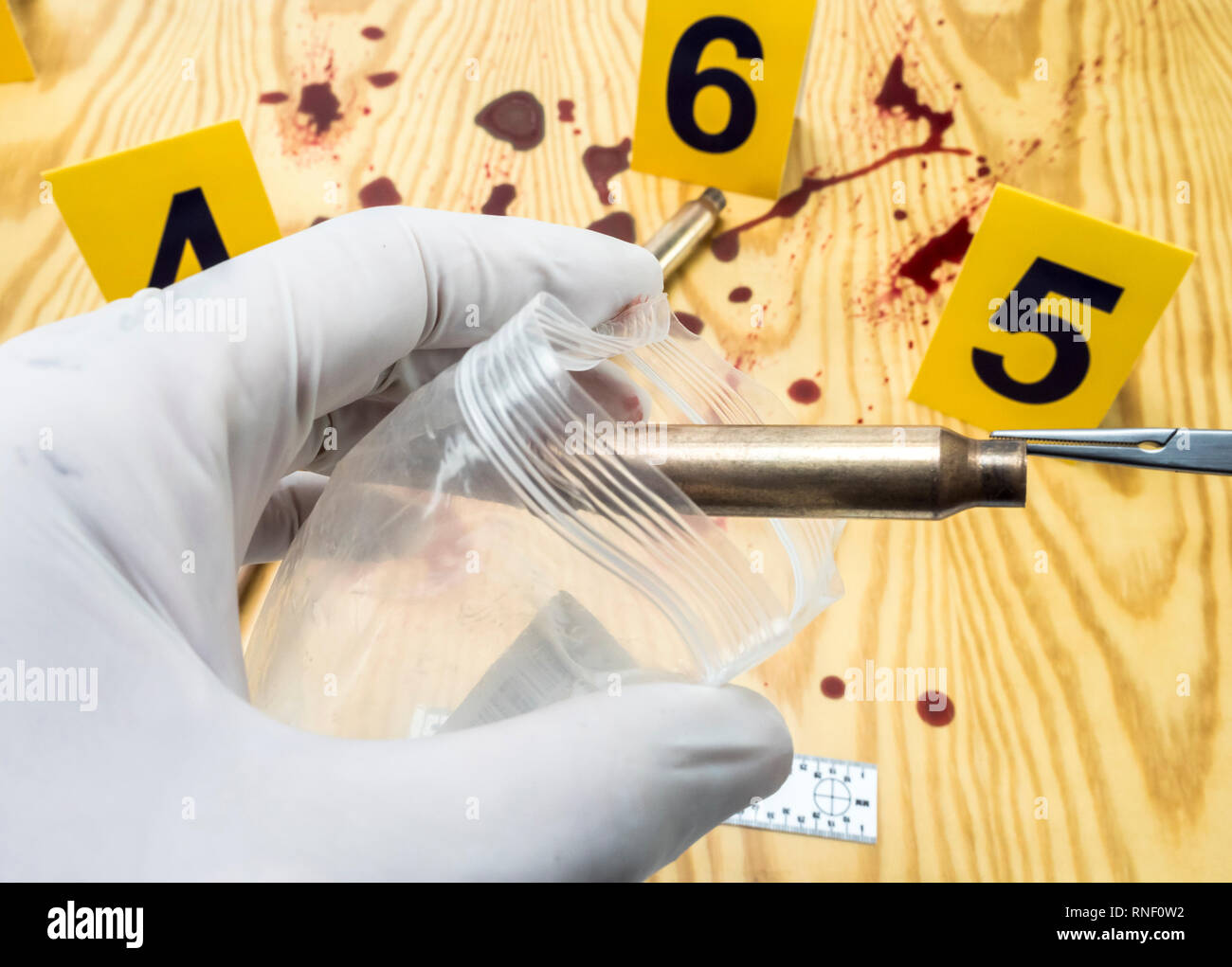 scene of crime, Scientific police picking up bullet cap with tweezers ...