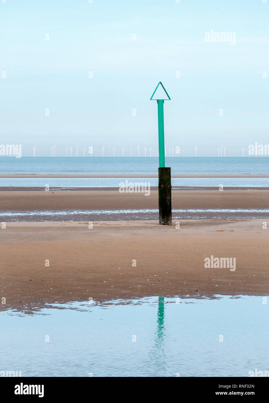 A green beach safety marker with a triangle on the top and an offshore ...
