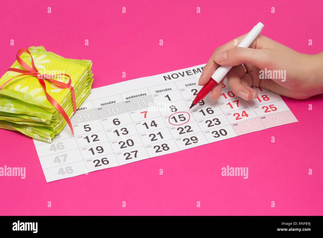 Female hand circle the days on the calendar with a felt-tip pen when ...