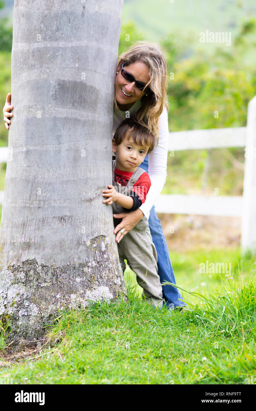 Happy mother and boy hugging a tree, enjoying the tree Stock Photo - Alamy