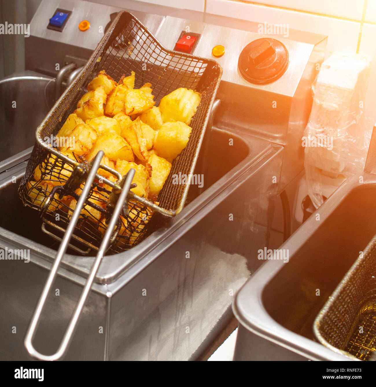 Cooking french fries and country fries in a fast food restaurant, close ...