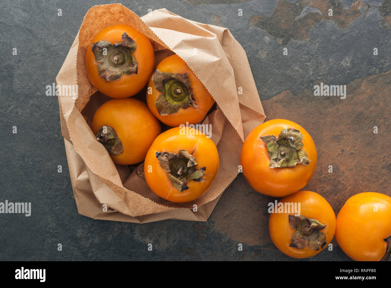 top view of ripe and whole persimmons in paper packet Stock Photo - Alamy
