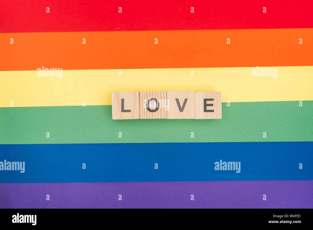top view of love lettering made of wooden blocks on paper rainbow ...