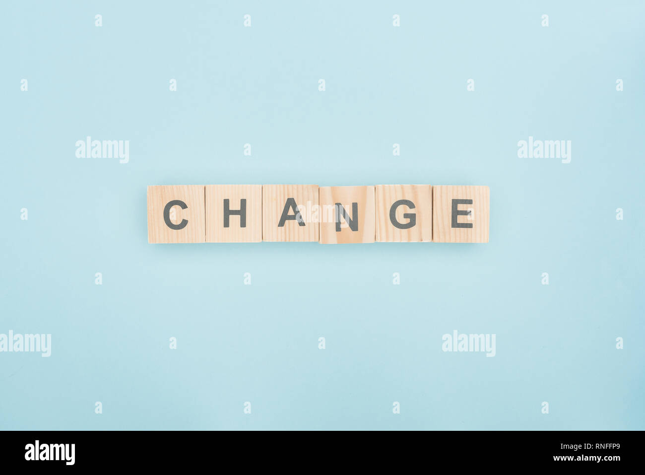 top view of change lettering made of wooden blocks on blue background ...