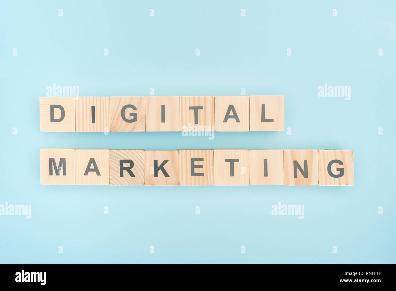 top view of digital marketing lettering made of wooden cubes on blue ...