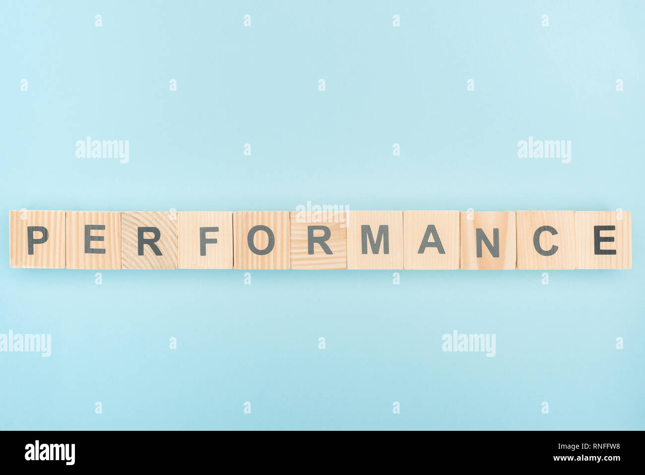 top view of performans lettering made of wooden cubes on blue ...