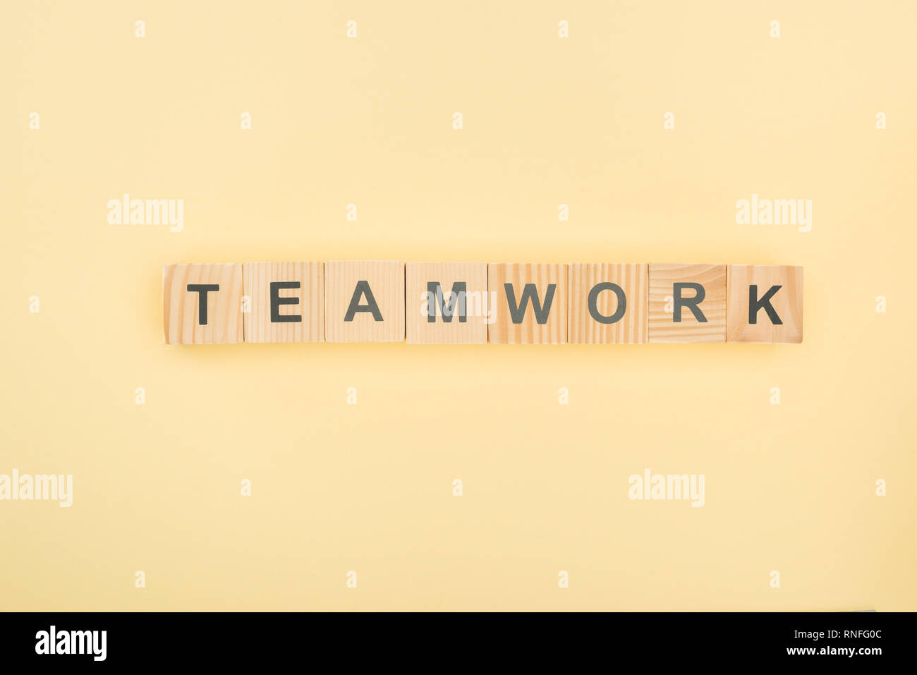top view of team work lettering arranged of wooden blocks on yellow ...