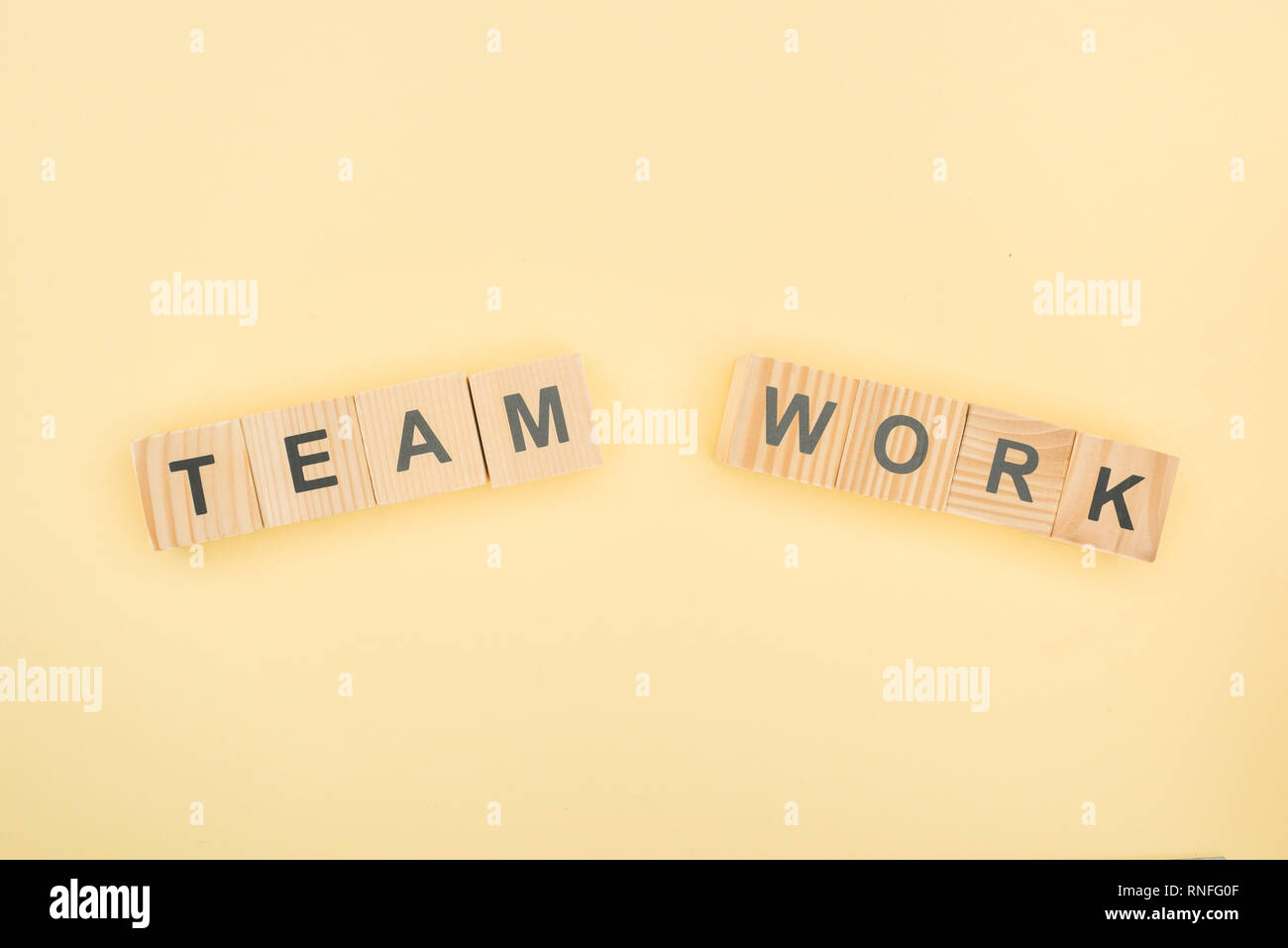 top view of team work lettering made of wooden cubes on yellow ...
