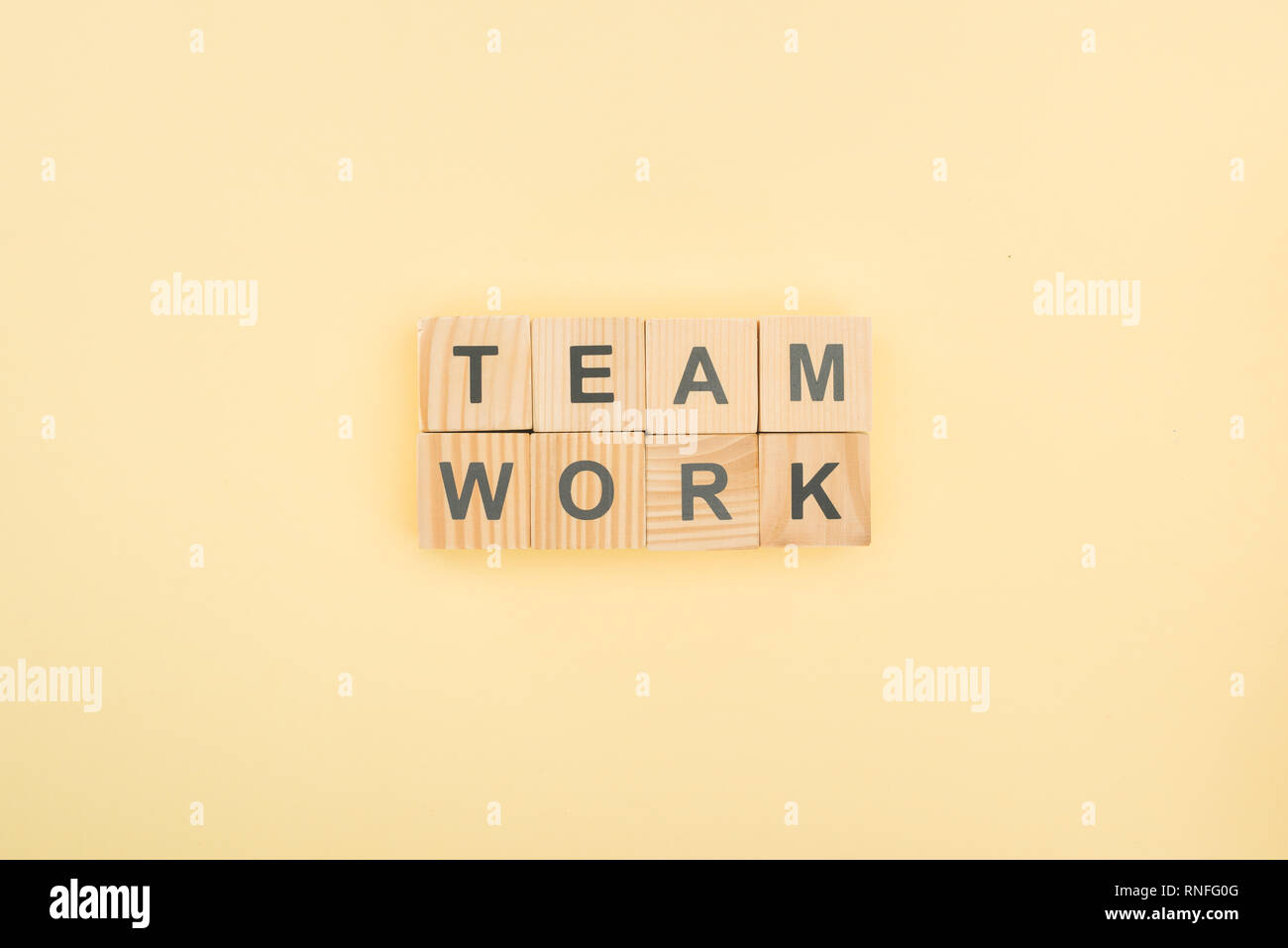 top view of team work lettering made of wooden blocks on yellow ...