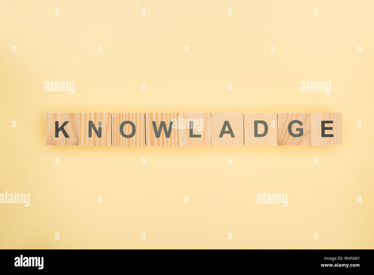 top view of knowledge lettering with mistake made of wooden cubes on ...