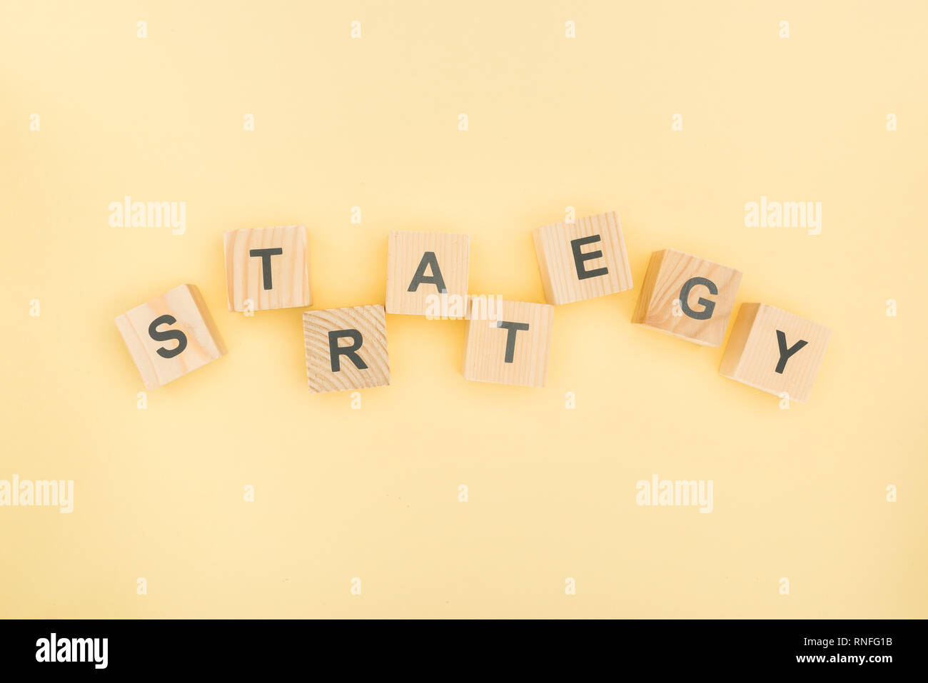 top view of strategy lettering made of wooden blocks on yellow ...