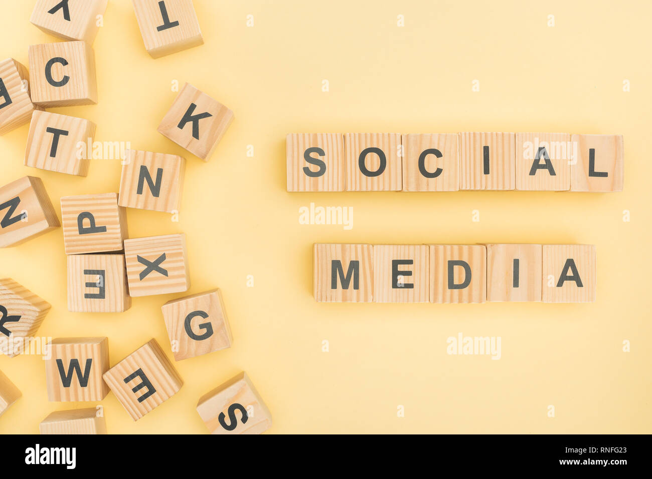 top view of social media lettering with wooden cubes on yellow ...