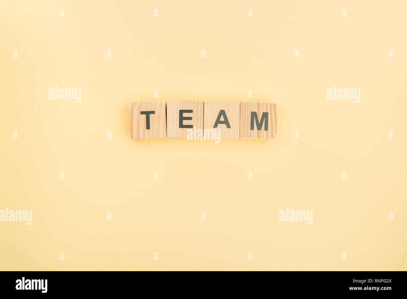 top view of team lettering made of wooden cubes on yellow background ...