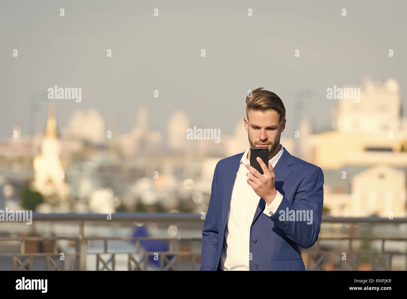 Businessman serious face received important message, skyline background ...