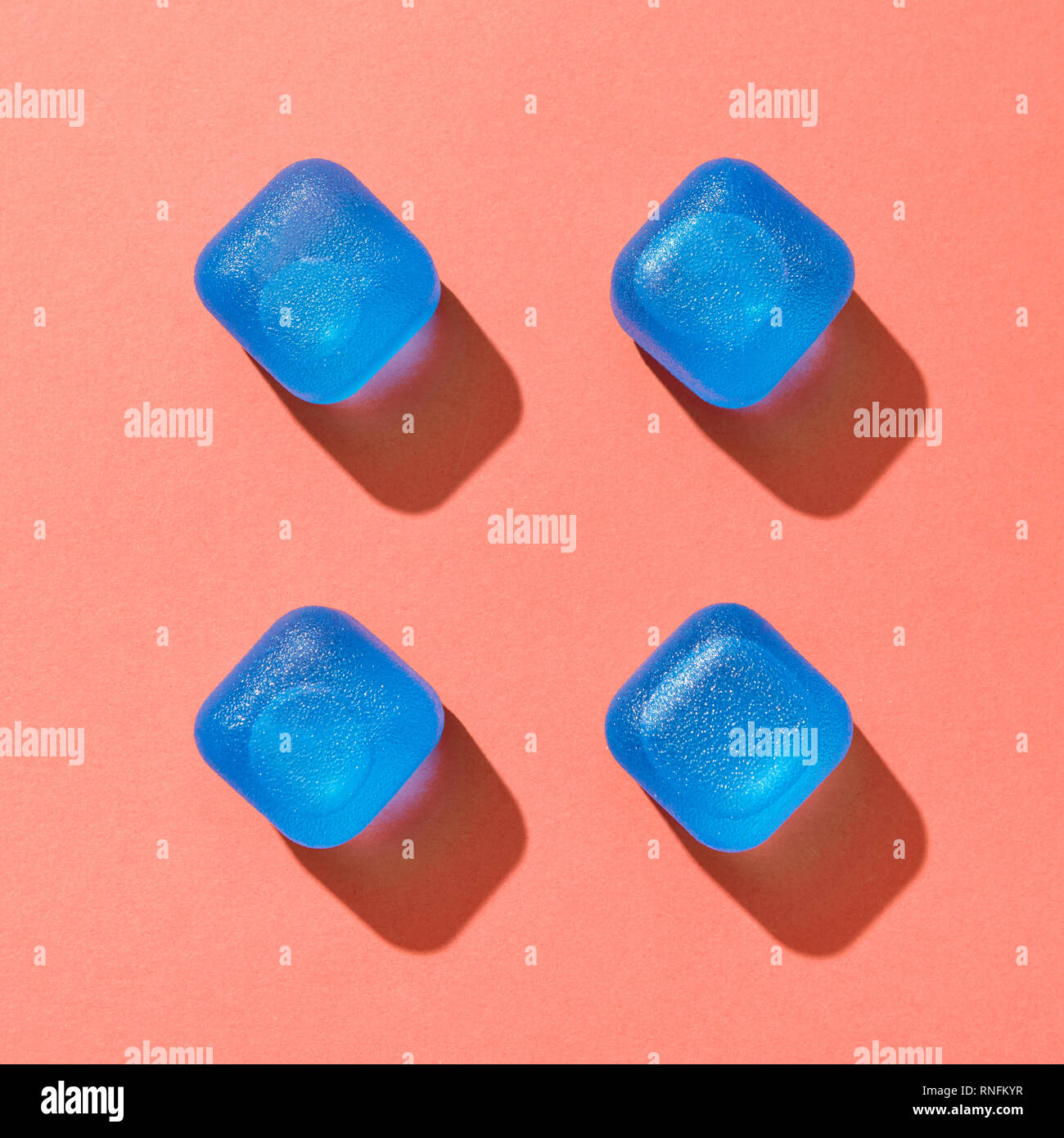 Four blue ice cubes with shadows on a background in a trend color of ...