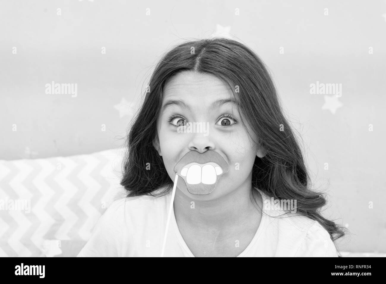 Just for fun. Happy little girl. Little girl hold fake mouth on face ...