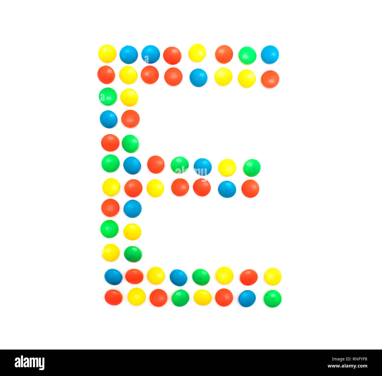 Multi-colored vitamins pills that are lined with the letter Vitamin E ...