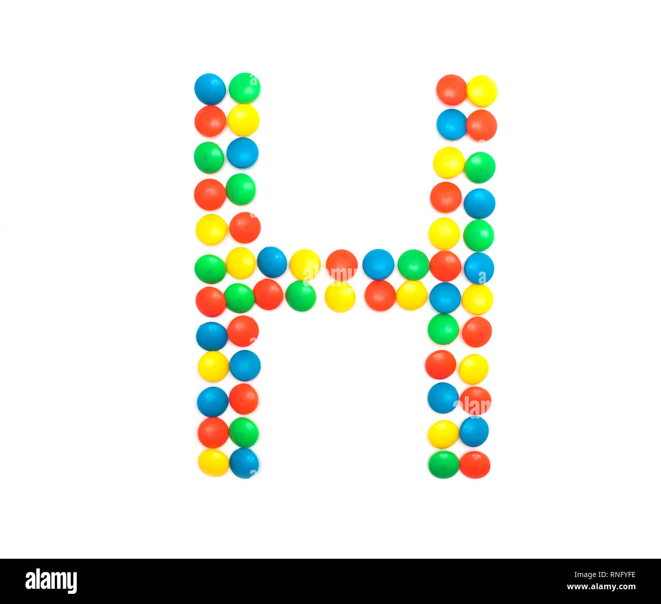 Multi-colored vitamins pills that are lined with the letter Vitamin H ...