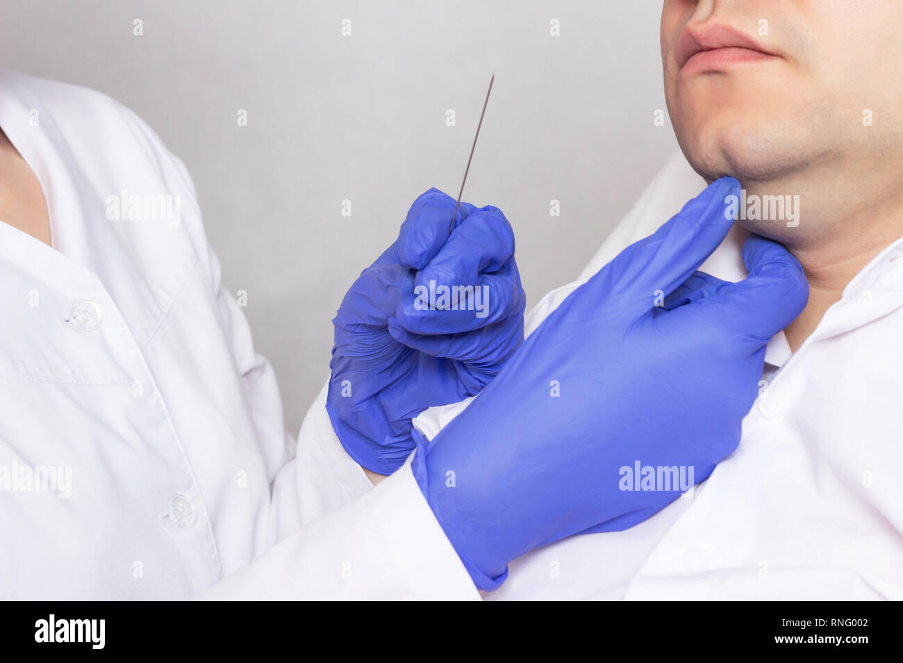 The cosmetologist does the procedure for a man to reduce the double ...
