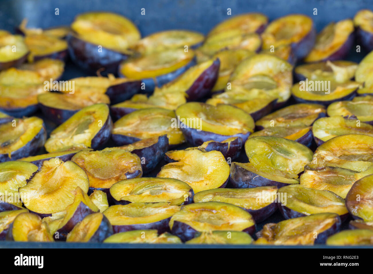 Plums cut in half prepared to be sun dried in a village in the Eastern ...