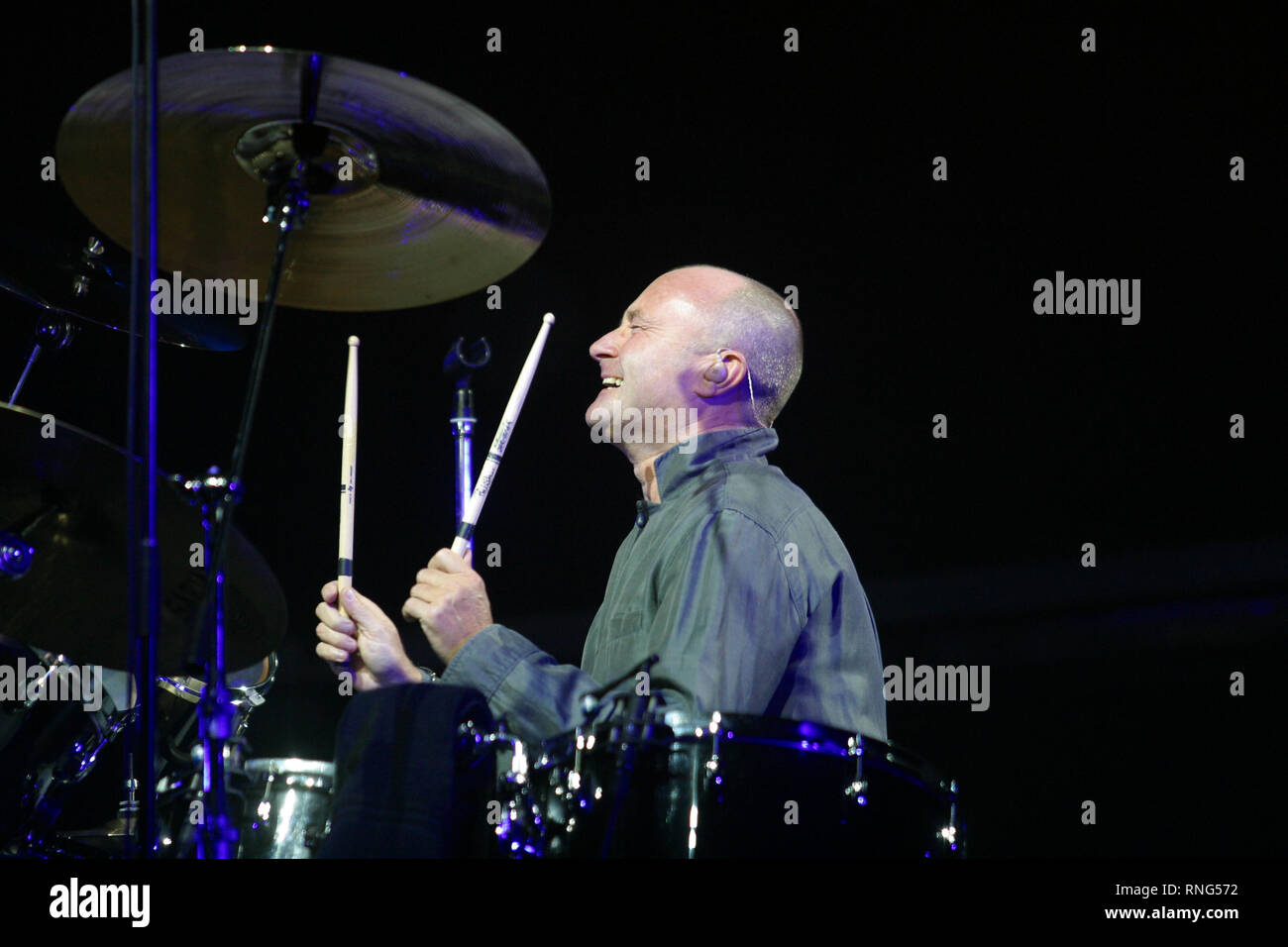Musician Phil Collins is shown performing on stage during a "live ...