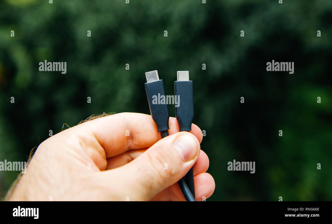 Man holding new black USB-c thunderbolt cable for ultra-fast connection ...