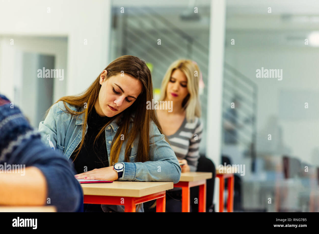 Group of young students writing notes in the classroom Stock Photo - Alamy