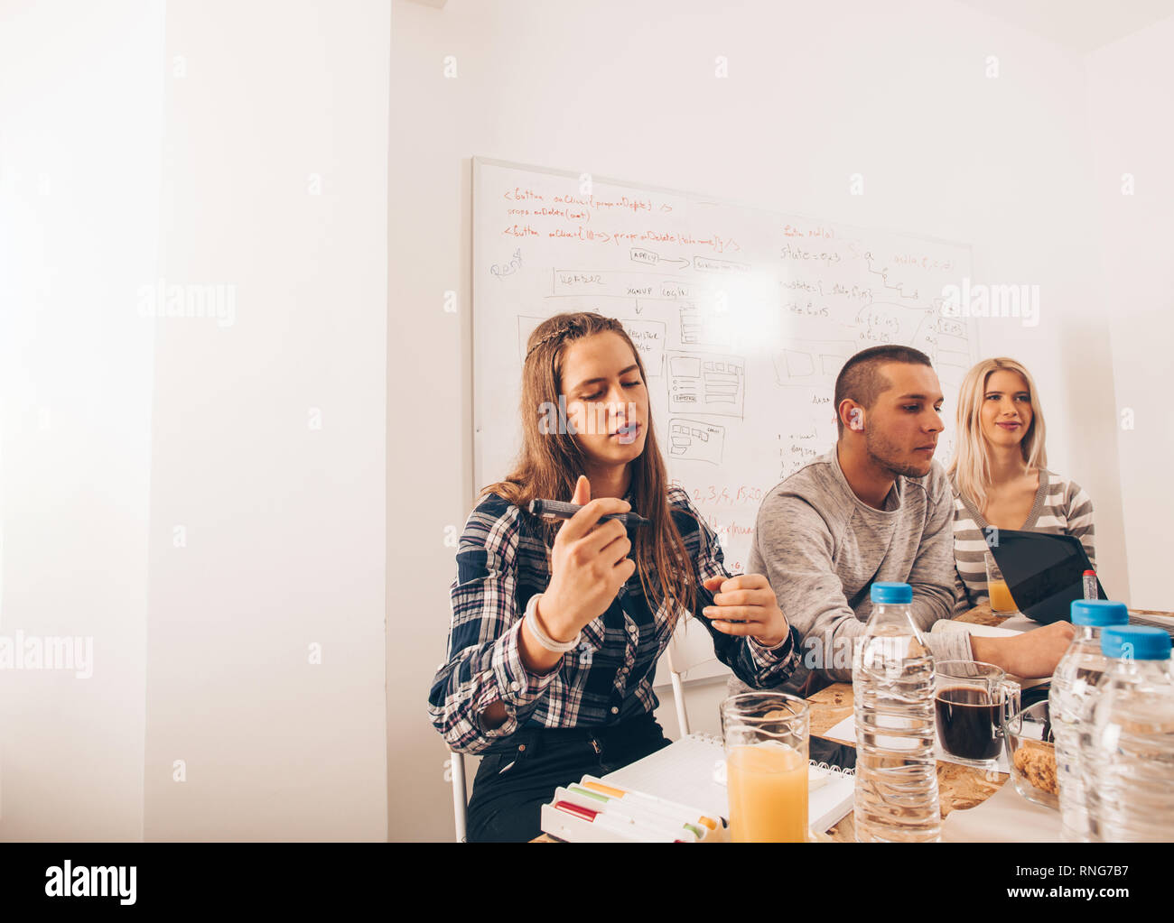 Professional young managers are sitting on the office table and making ...