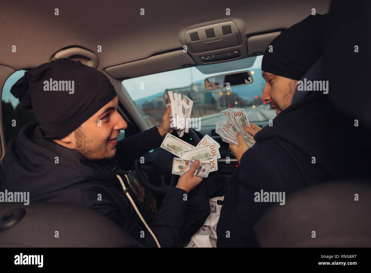 Two happy bank robbers celebrating their successful hit while sitting ...