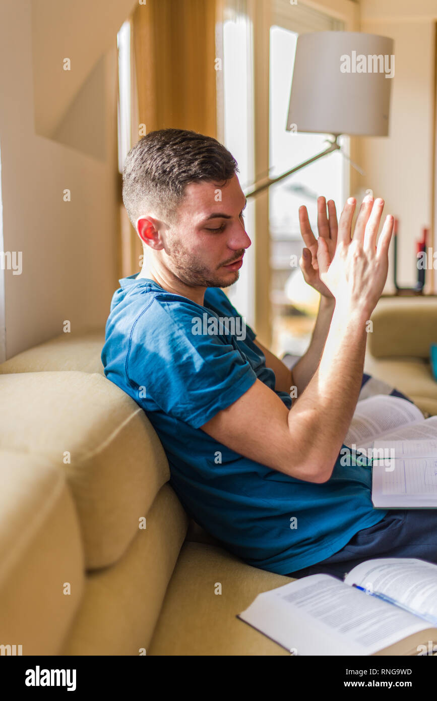 A young man is looking nervous from studying inside his home Stock ...