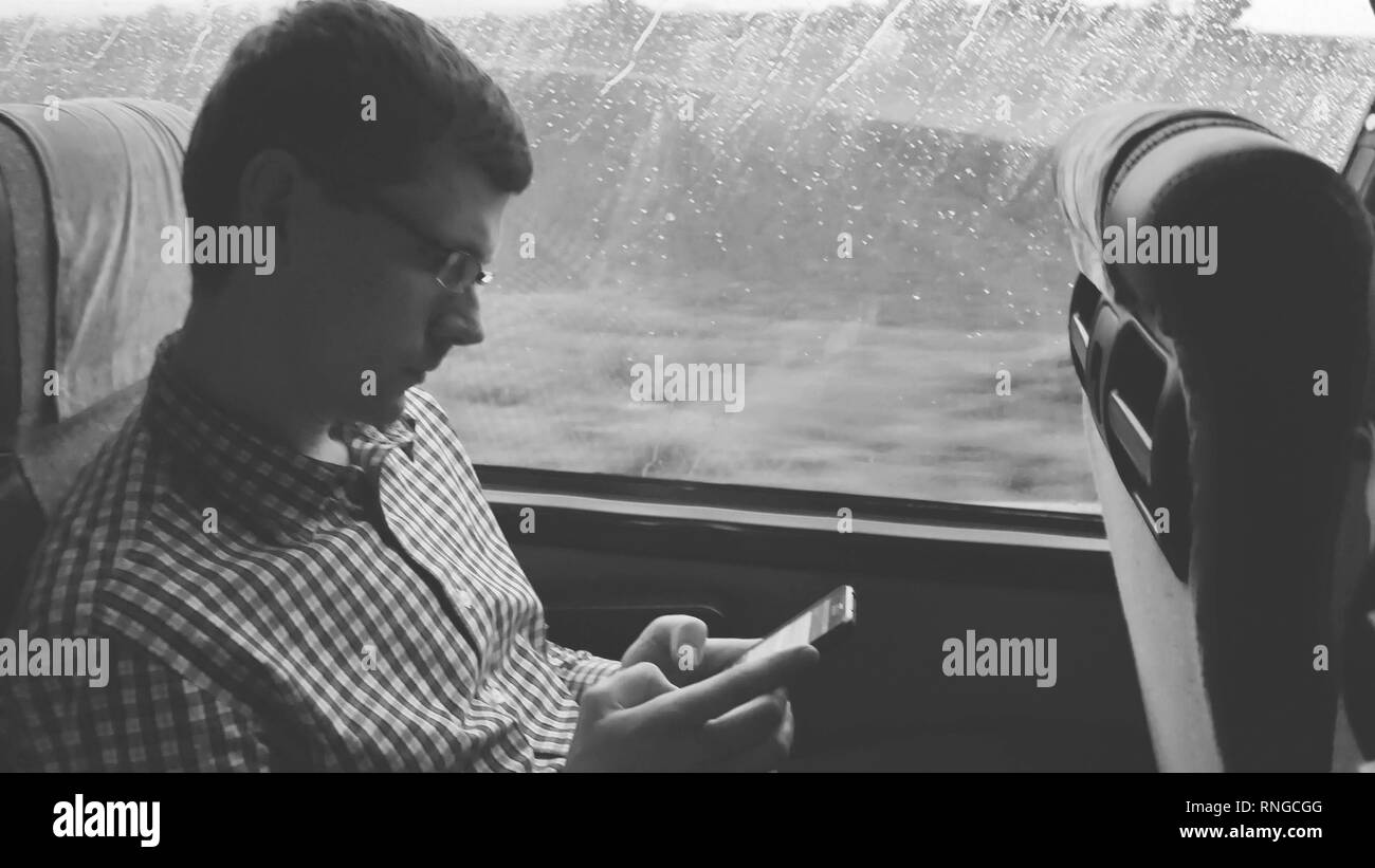 Man smartphone in commuter train Black and White Stock Photos & Images ...