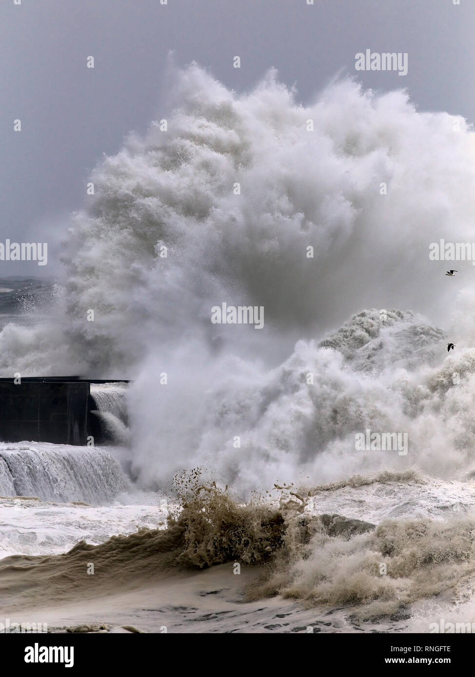 Huge stormy wave breaking over a pier from the north of Portugal Stock ...