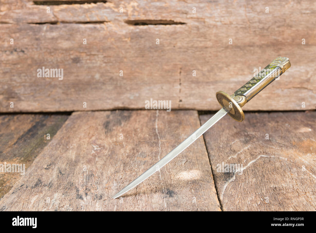 sword steel blade samurai pierce on old wooden surface floor with copy ...