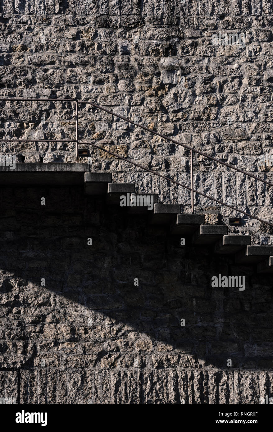 Outside stairs side view in the morning light against a stone wall ...