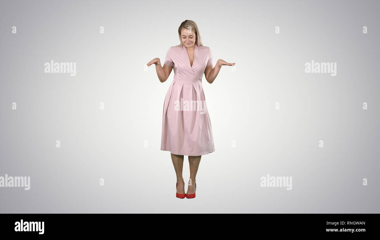Blonde lady dancing in pink dress on gradient background Stock Photo ...
