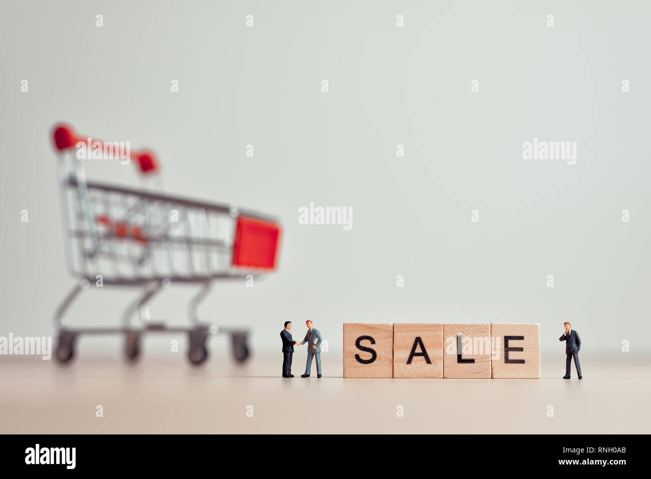 SALE sign in front of miniature businessmen. Retail concept Stock Photo ...