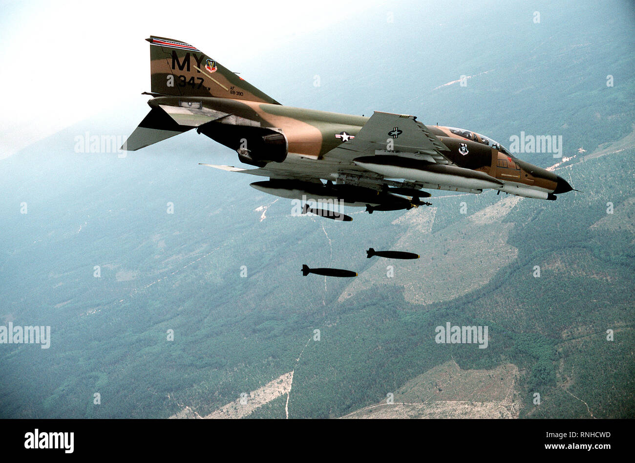 1980 - An air-to-air right side view of an F-4E Phantom II aircraft dropping six Mark 82 500 ...