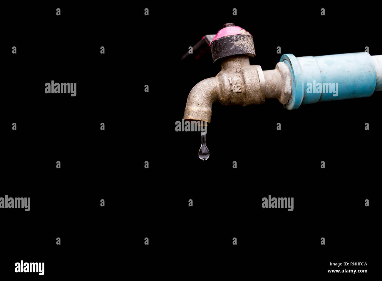old rusty tap leaking water isolate on black background Stock Photo - Alamy