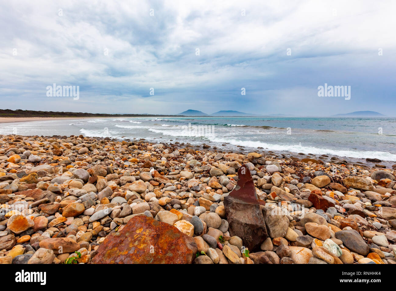 Vivid orange pebbles on ocean beach at Crowdy Head, NSW, Australia ...