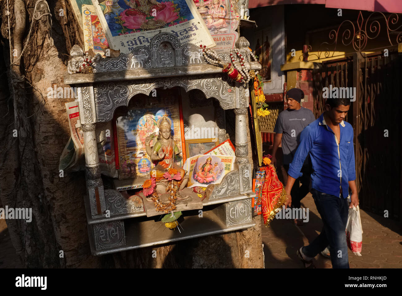 An improvised prayer shrine attached to a tree in Mumbai, India, with a ...
