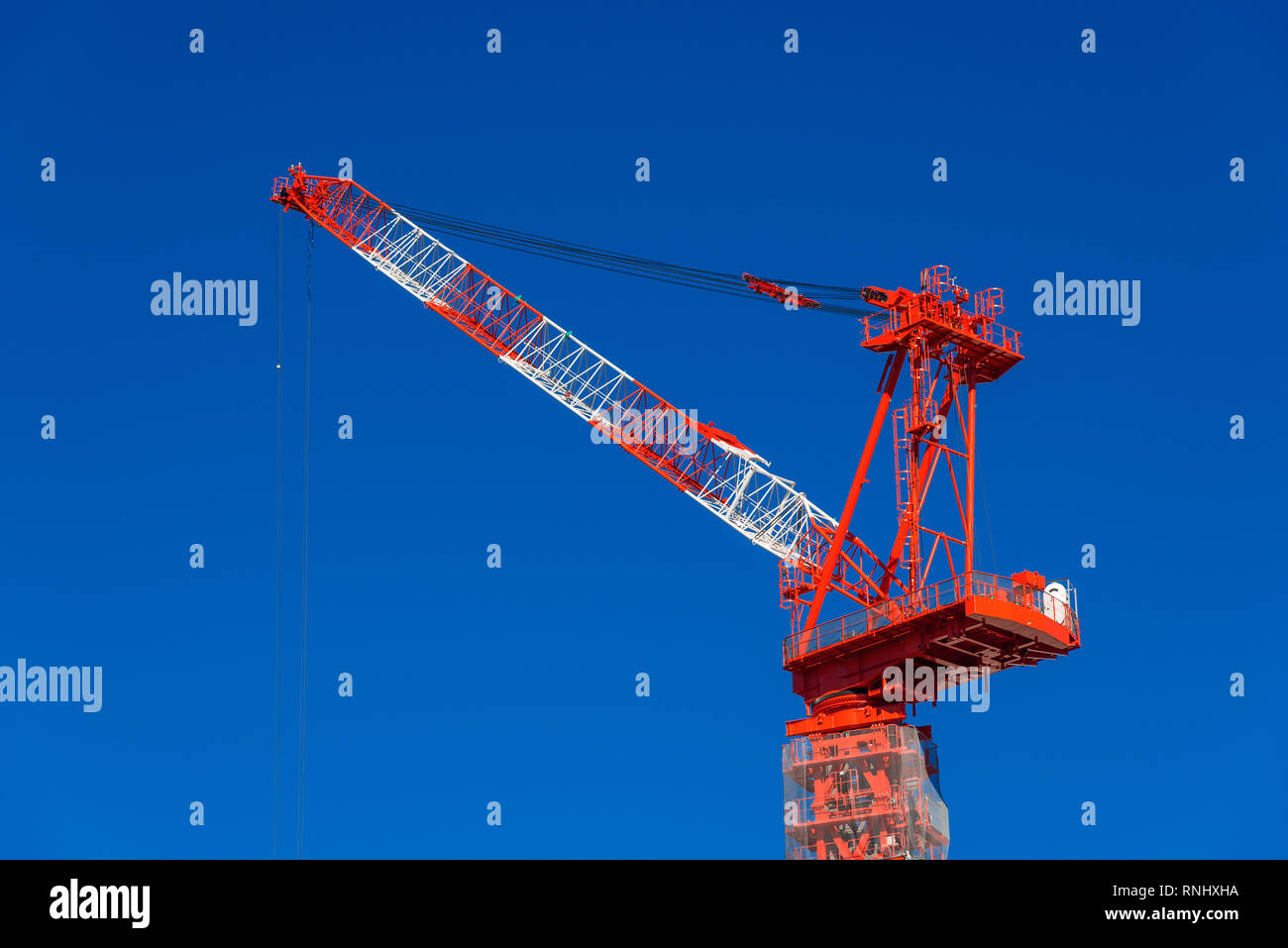 Construction fixed crane at work against a blue sky Stock Photo - Alamy