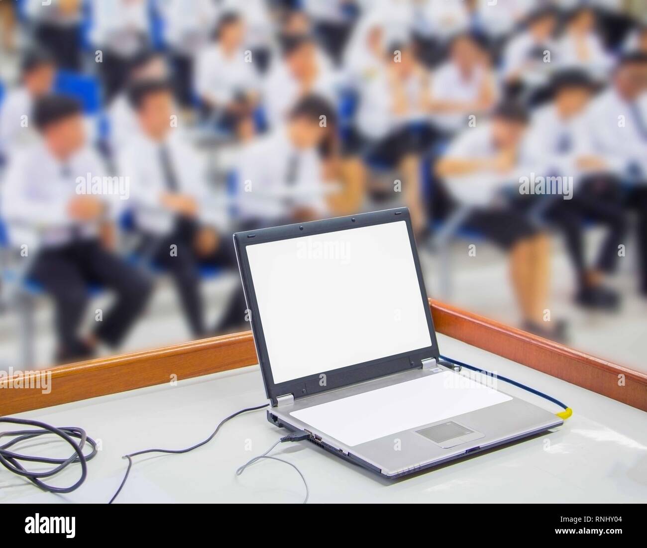 computer on the table and group students blur sitting in the a ...