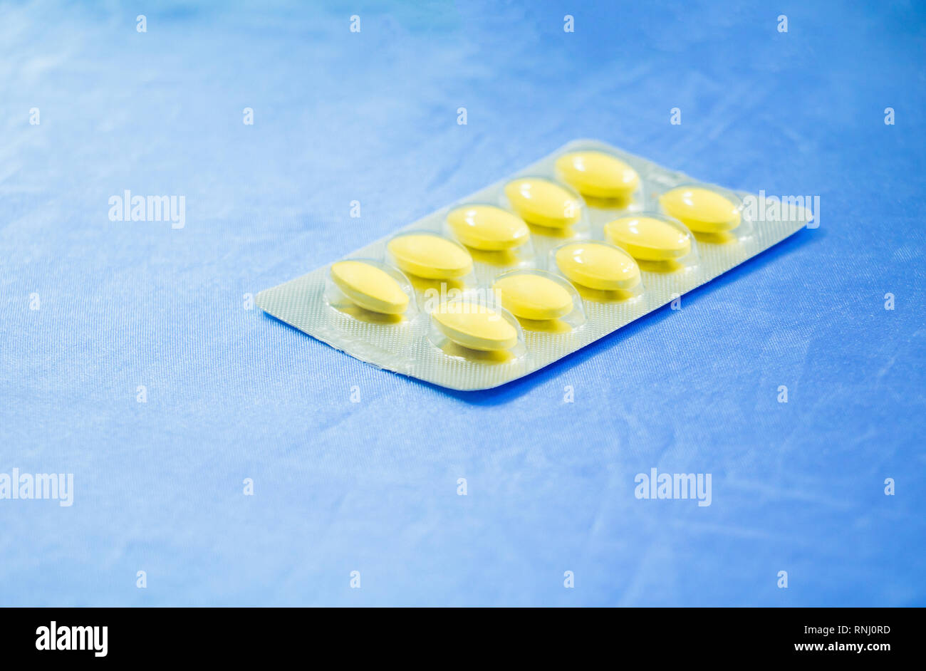 drug yellow or treatment medication in packages plastic pill. on blue ...