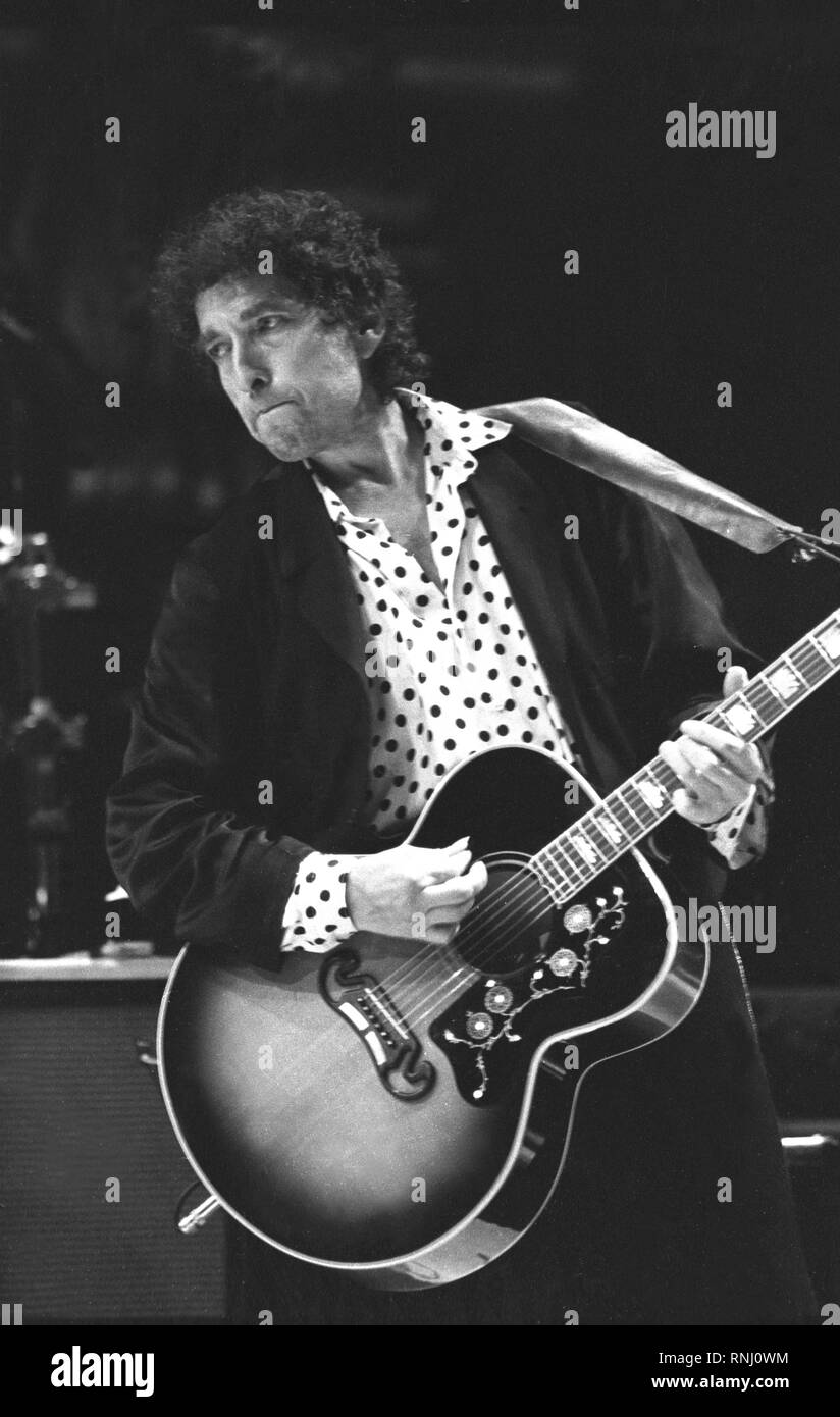 Musician Bob Dylan is shown performing on stage during a "live" concert ...