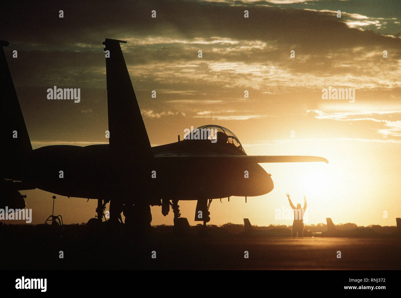 1981 - An eye-level view of an F-15 Eagle aircraft being marshalled by ...
