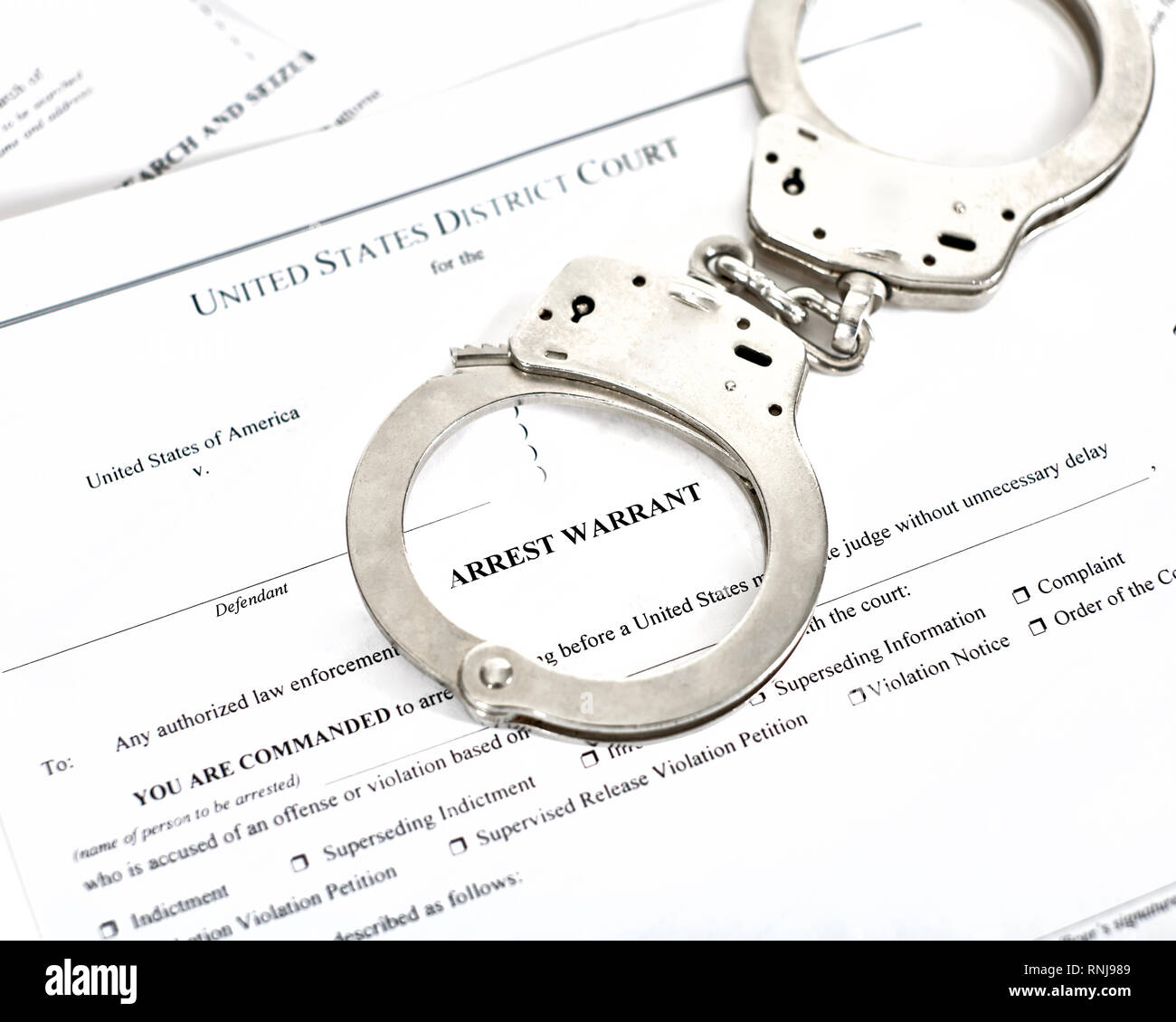 District Court Arrest Warrant court papers with handcuffs isolated on ...