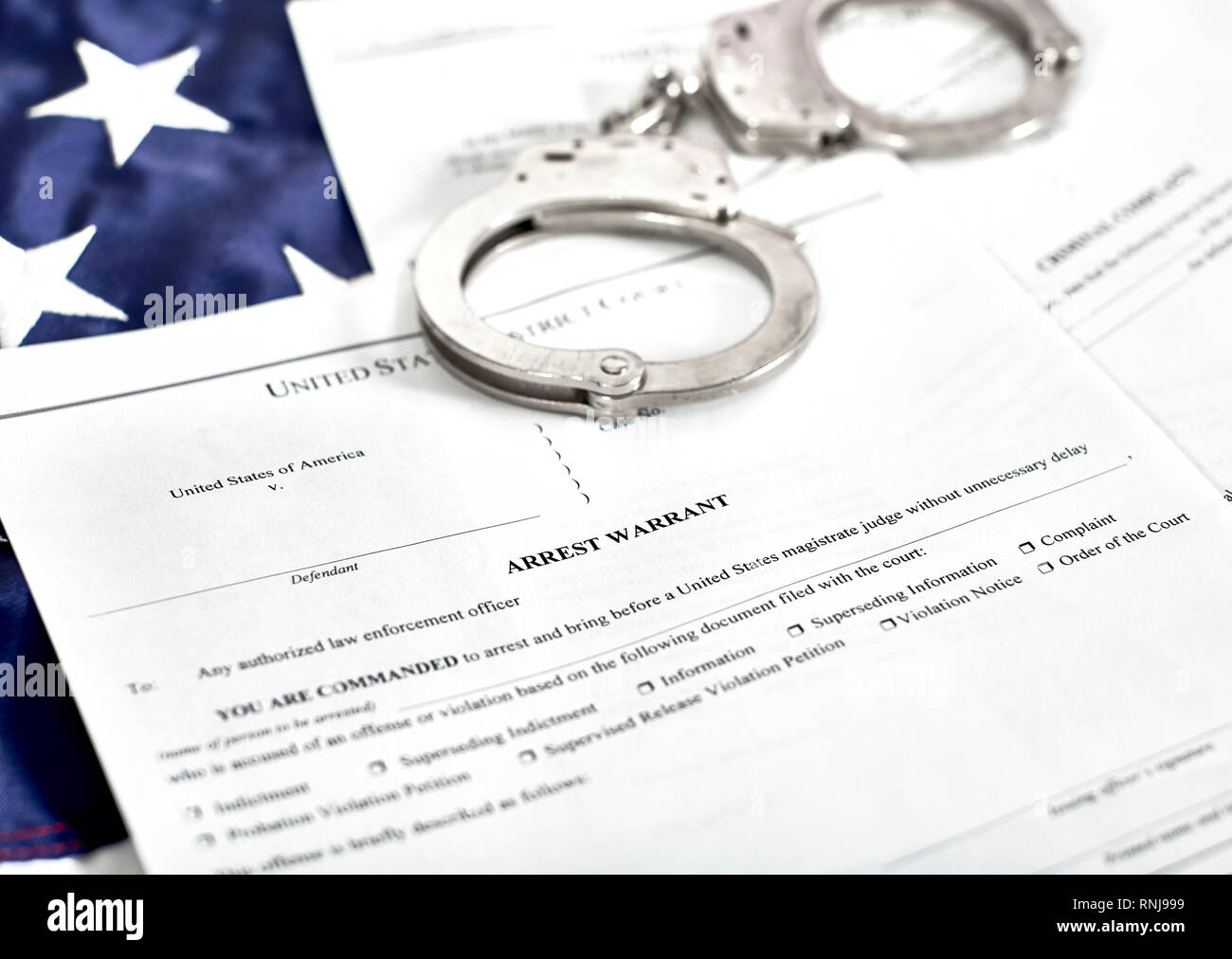 District Court Arrest Warrant court papers with handcuffs on the ...